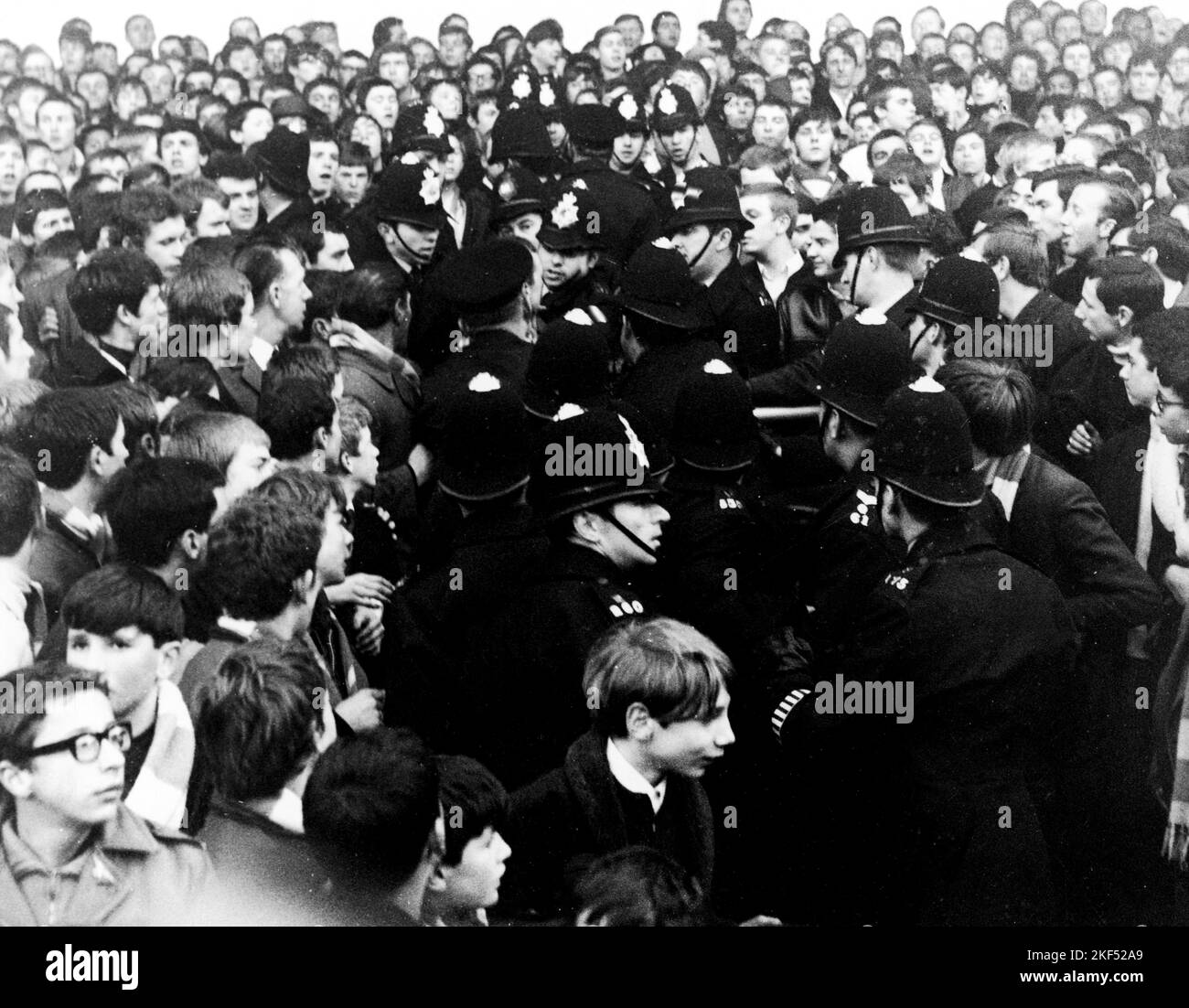 Police struggle to remove rowdy fans from the crowd behind the goal ...