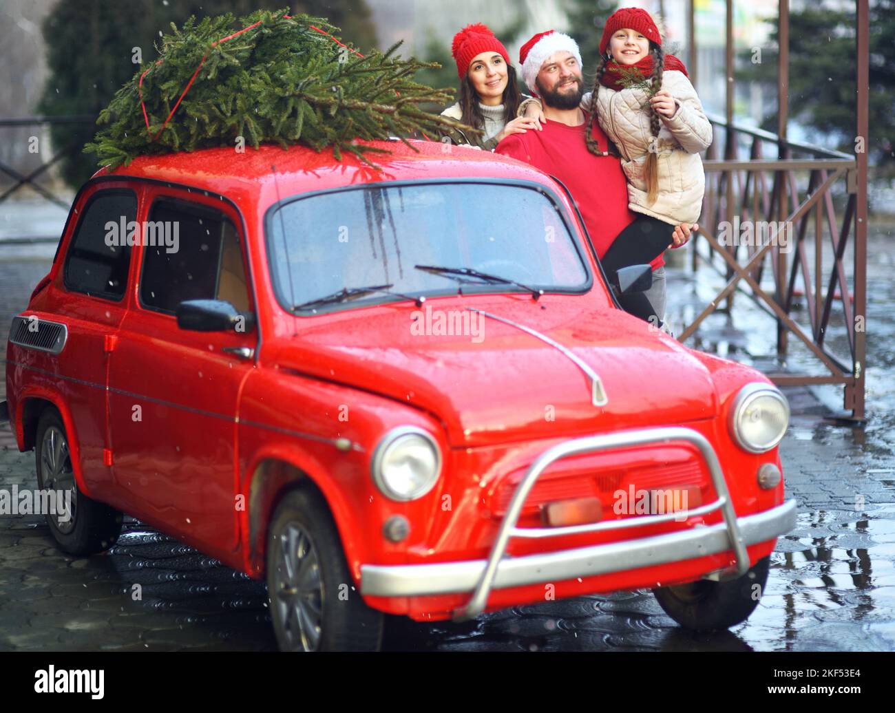 Mother Daughter And Father In Santas Hat Are Hugging And Smiling On