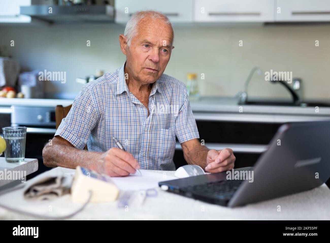 Old man writing recomendations of doctor during online consultation ...