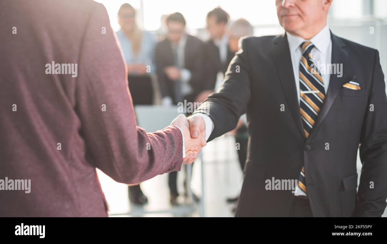 close up. serious businessman meeting his business partner with a handshake Stock Photo - Alamy