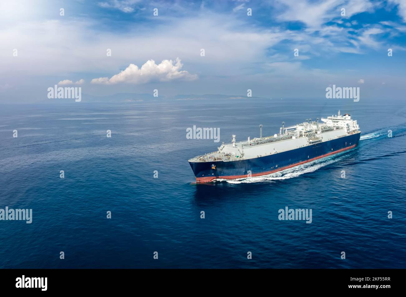 Front view of a big LNG tanker ship travelling over the calm, blue ...
