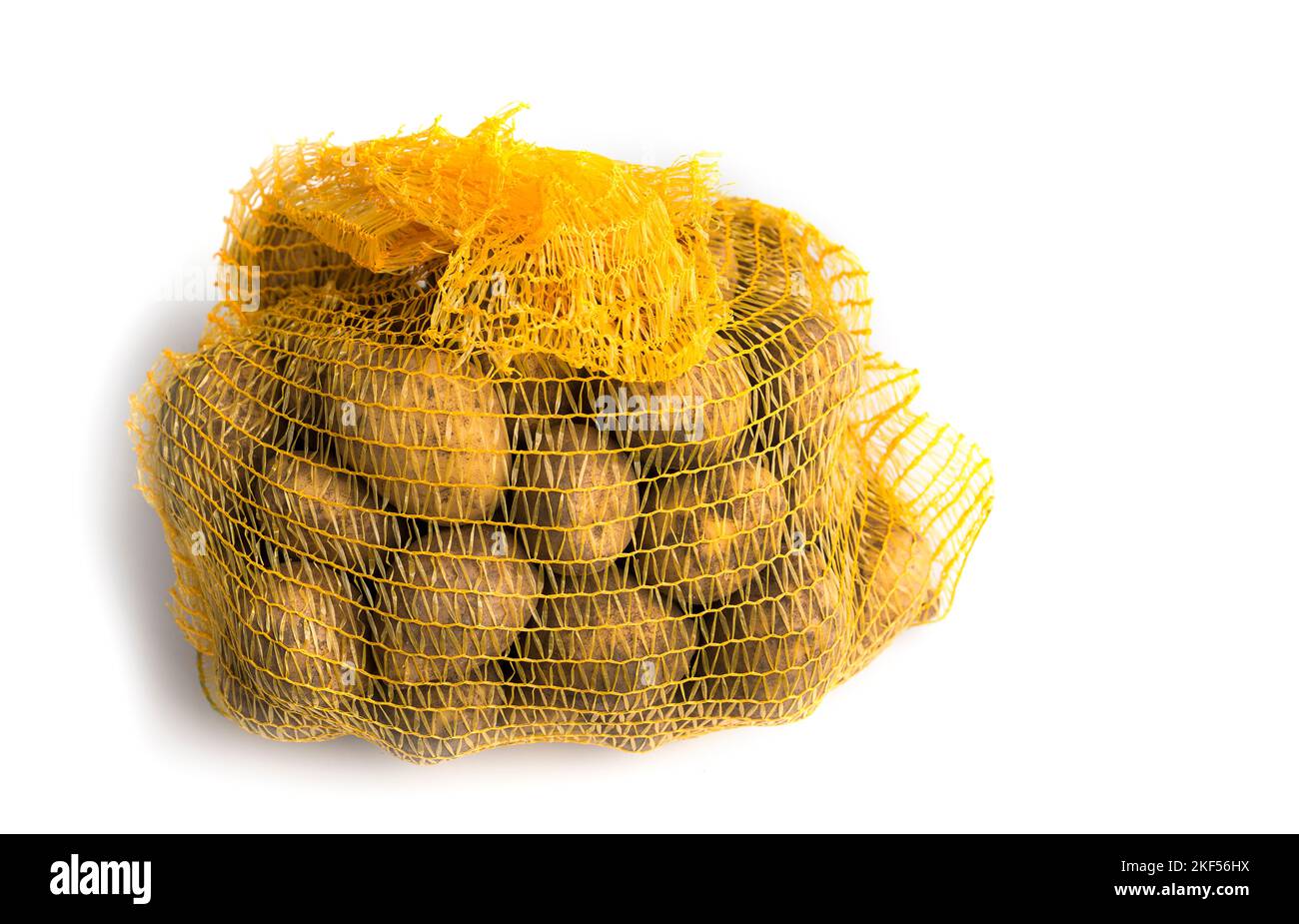Unwashed potatoes in the mesh on a white background Stock Photo - Alamy