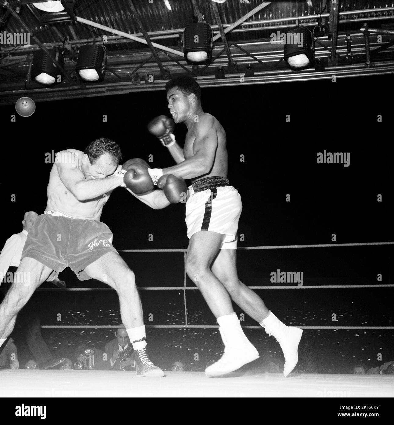 Muhammad Ali (r) begins a combination as Henry Cooper (l) tries to duck ...