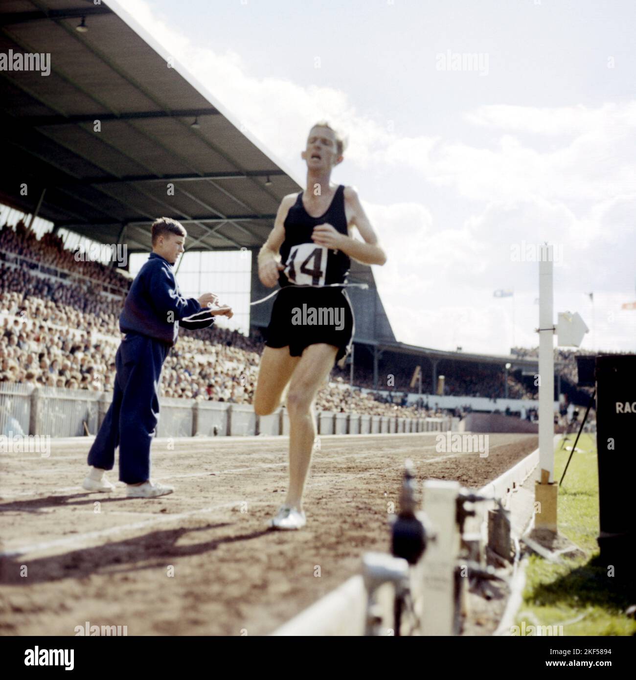 Murray Halberg, New Zealand, breaks the tape to win the three mile race ...