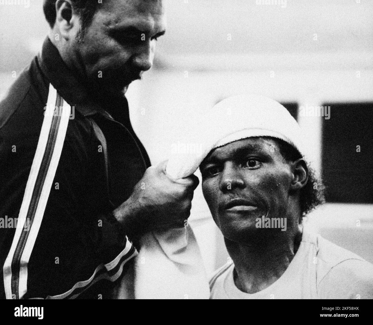Don Curry (r) is put through a vigorous neck exercise by his trainer ...