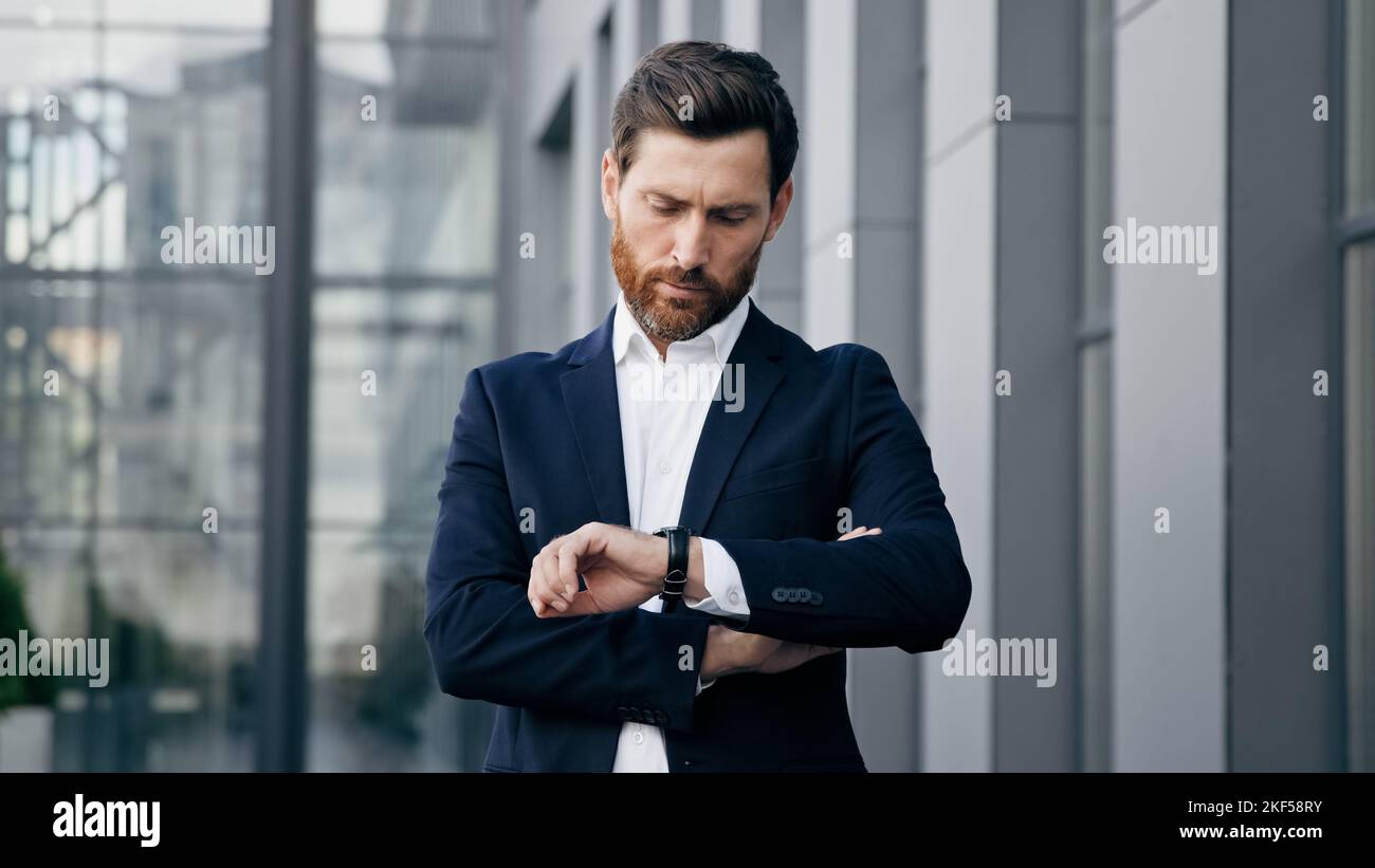 Professional confident businessman standing outdoors waiting for ...