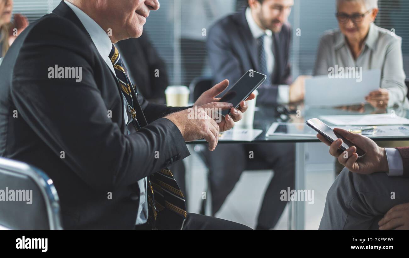 business colleagues using their smartphones during a work meeting Stock ...