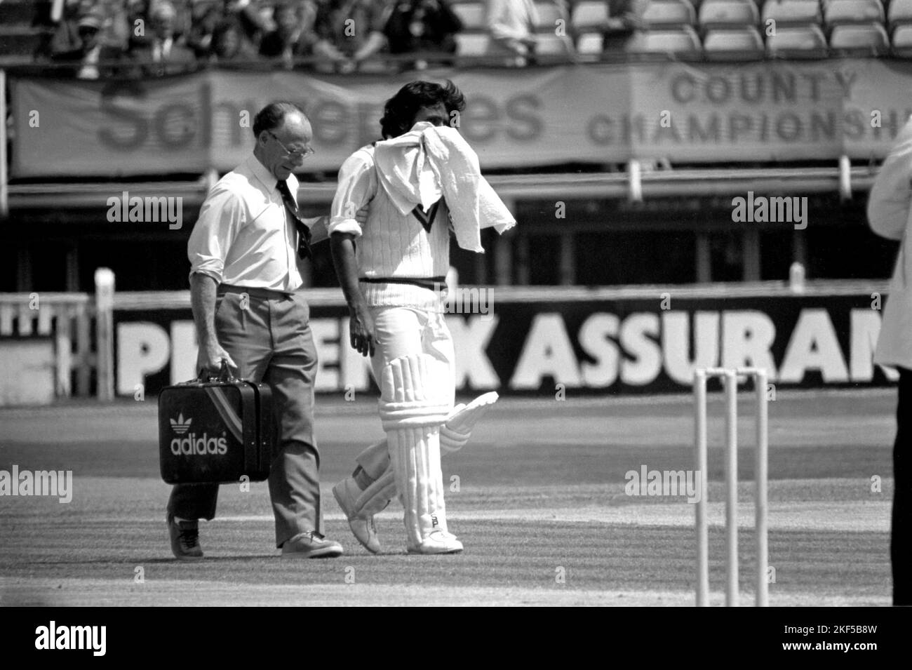Pakistan's Iqbal Qasim is led off with a towel covering his face after ...
