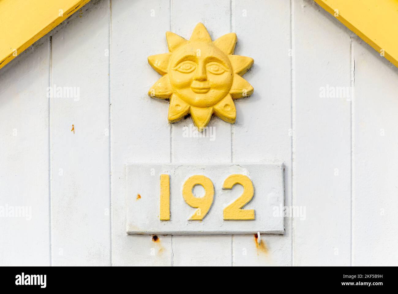 Detail of yellow sun face on numbered beach hut,Felixstowe, Suffolk ...