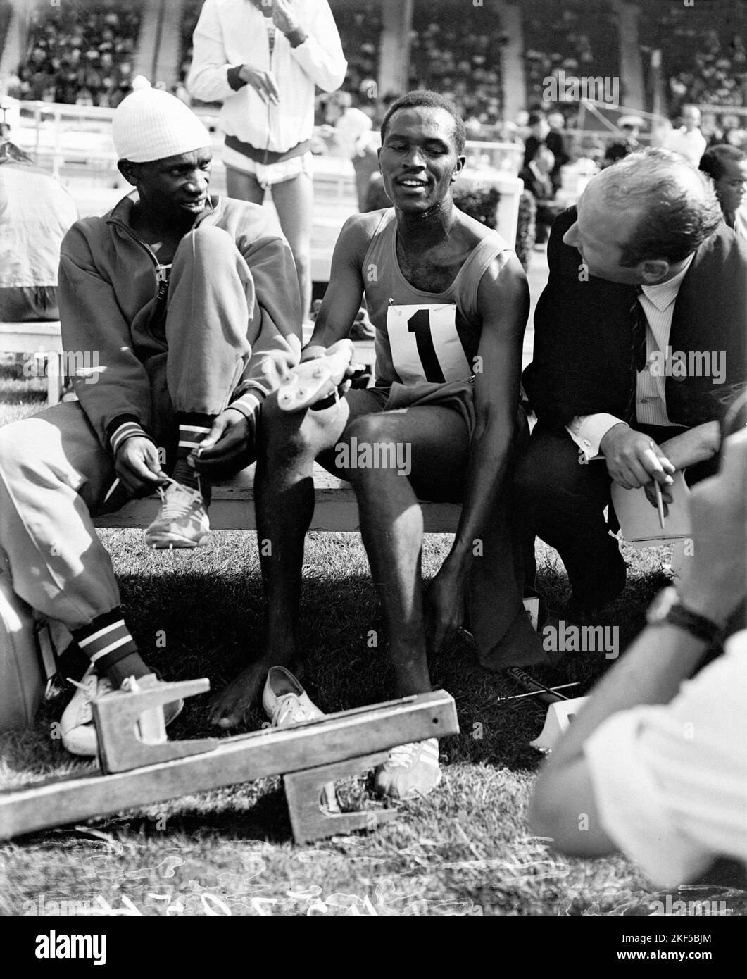 Kip Keino (c) removes his spikes after winning the Emsley Carr Mile ...
