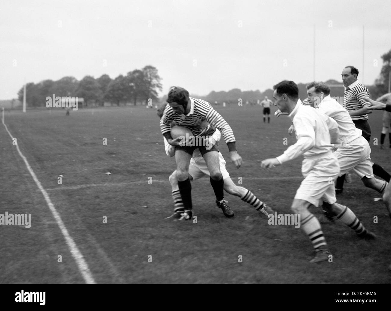 Peter Kininmonth (left in stripes) of Middlesex is tackled by A.C Pye ...