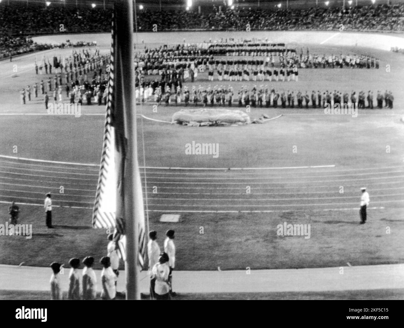The flag of the Games is raised in the foreground after the athletes ...