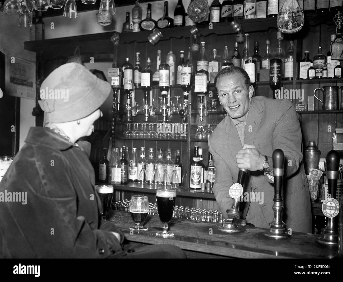 British and Commonwealth Heavyweight Champion Henry Cooper pulls a pint ...