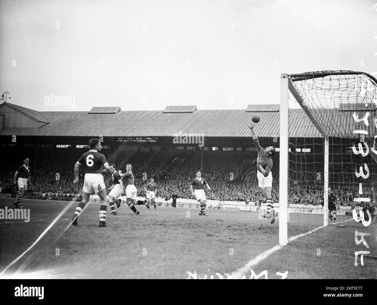 Birmingham City goalkeeper Gil Merrick (r) stretches to make a ...