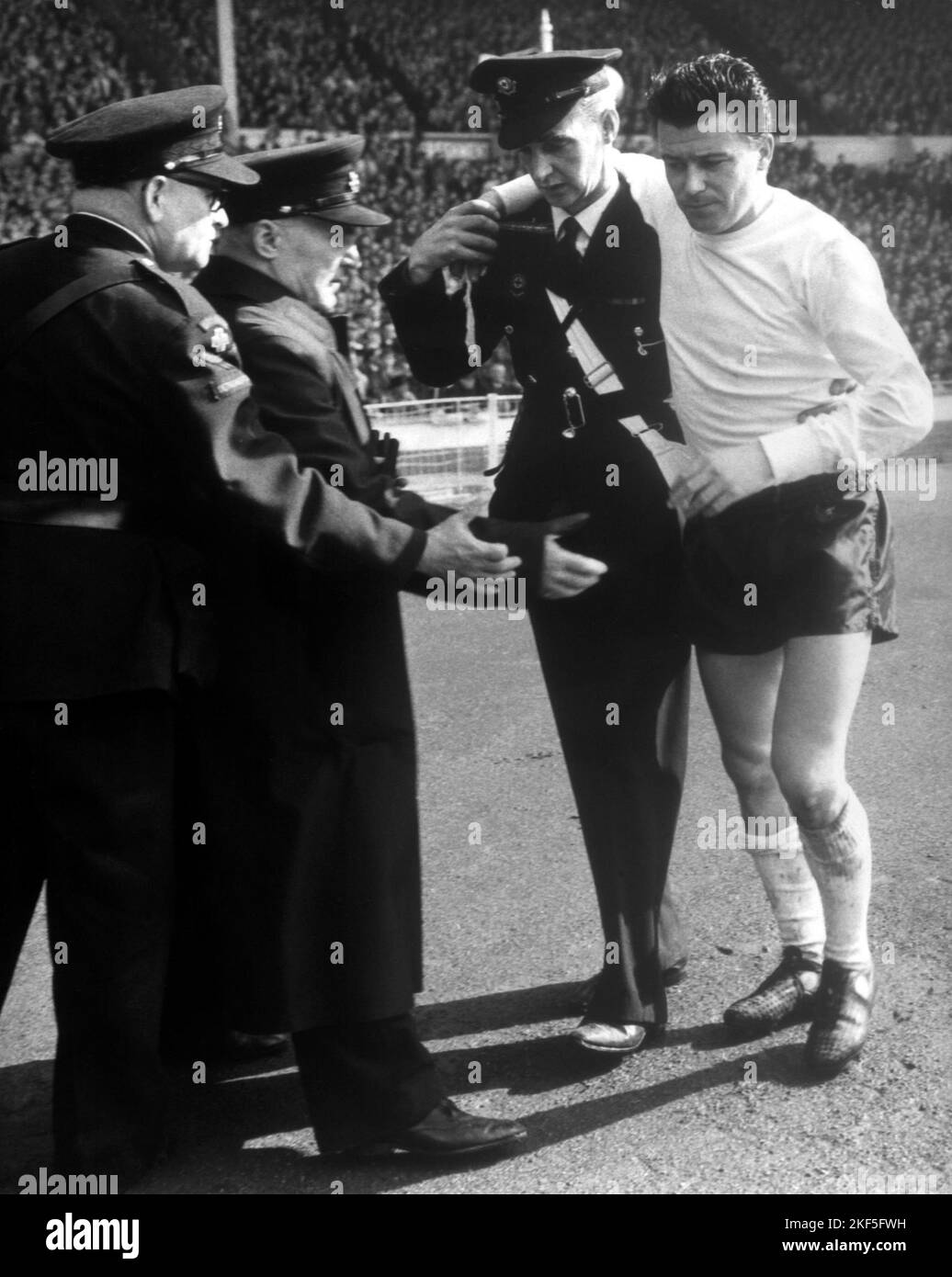 England's Johnny Byrne (r) is helped off the pitch by a St John's ...