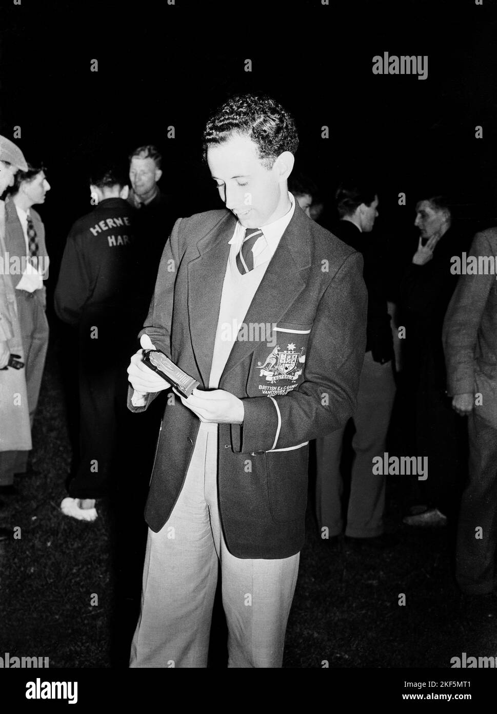 Australian miler John Landy examines the plaque which was awarded to ...