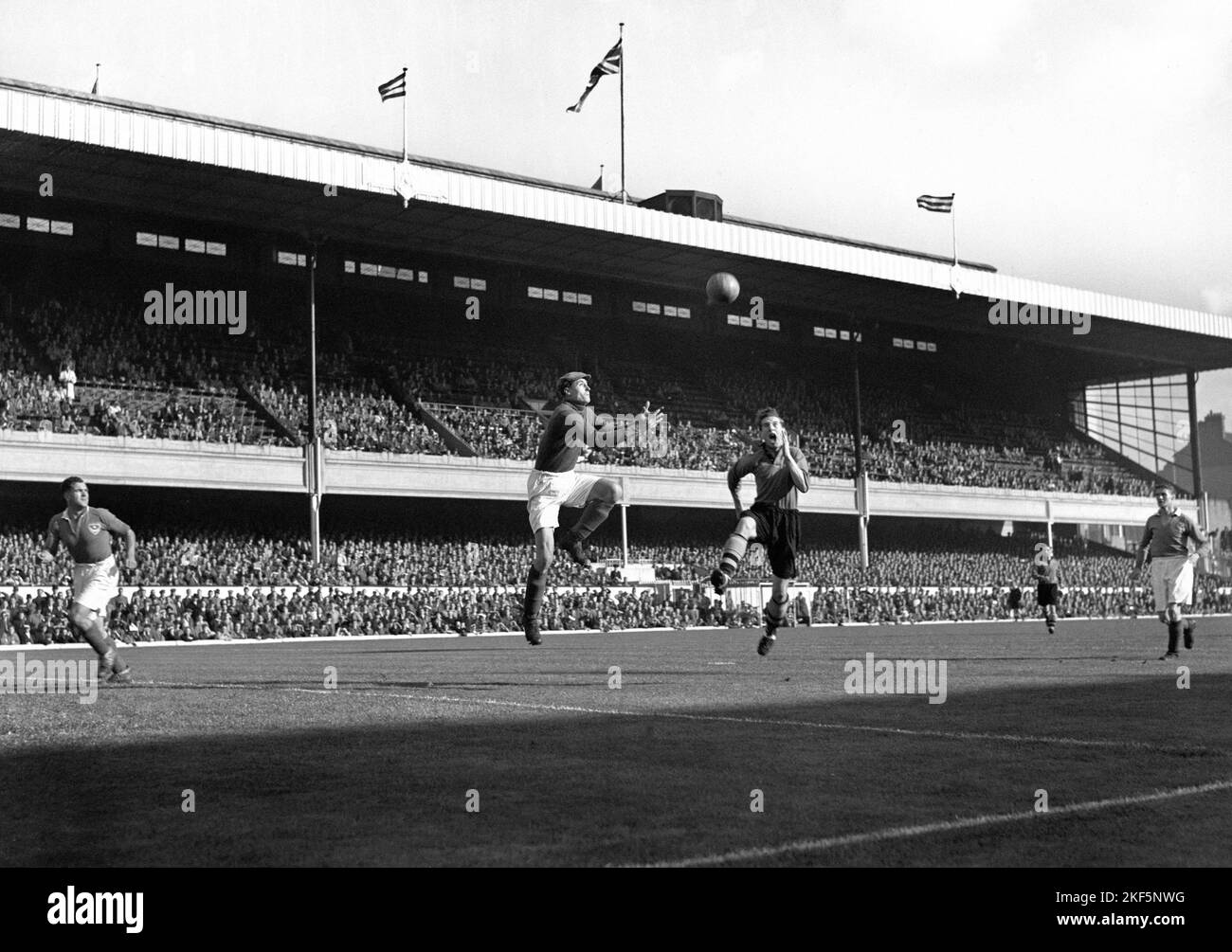 Ernest Butler, the Portsmouth goalkeeper and Samuel Smyth of Wolves go ...