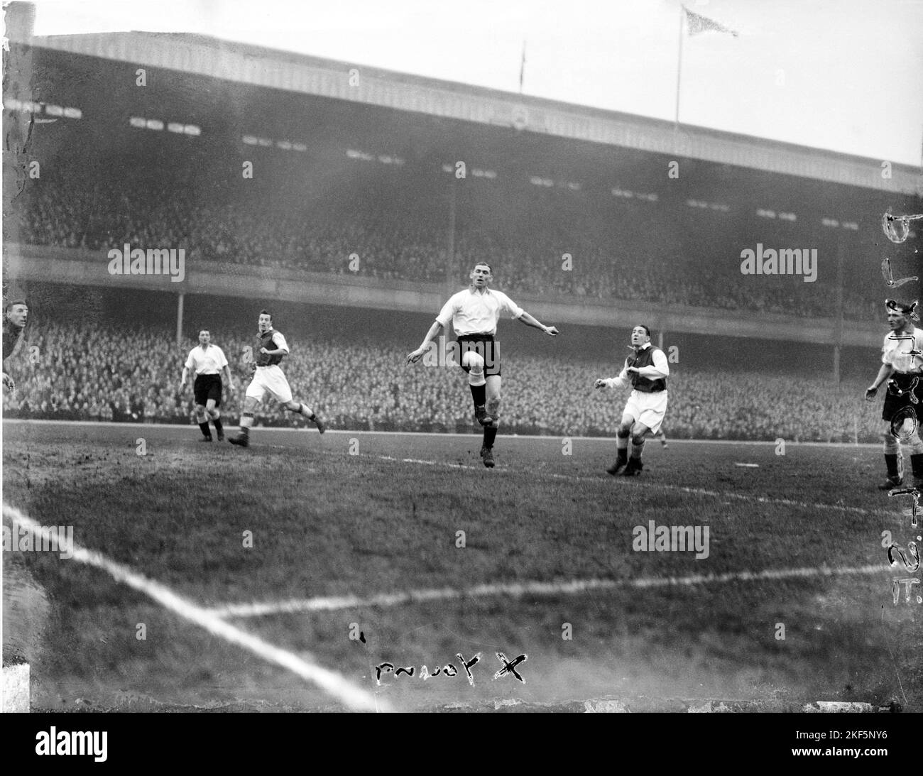 Sheffield United's Dick Young (c) wellies the ball clear as Arsenal's ...
