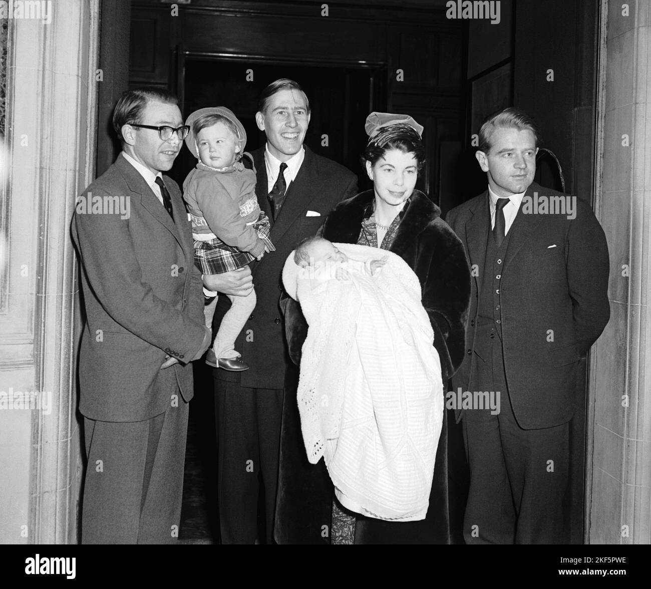 Dr Roger Bannister (second l) holds onto two year old daughter Erin as ...