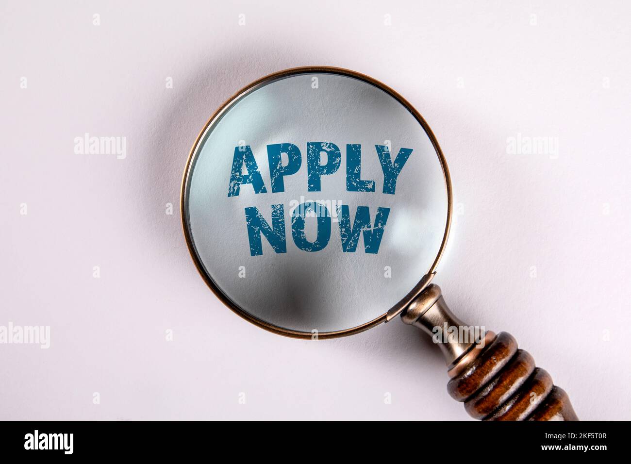 APPLY NOW. Text and magnifying glass on white background Stock Photo ...