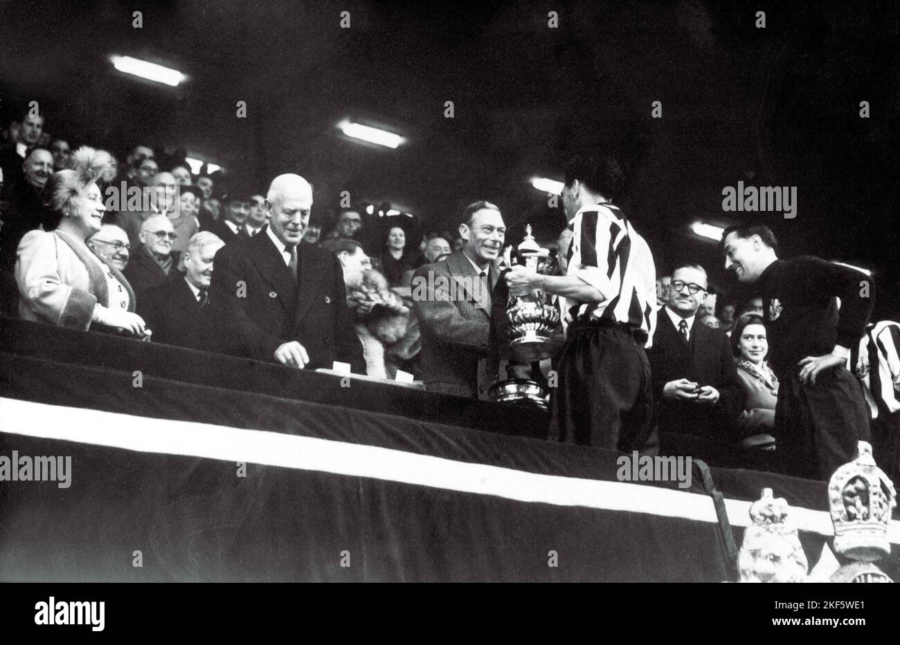 HRH King George VI (third l) presents the FA Cup to the winning captain ...