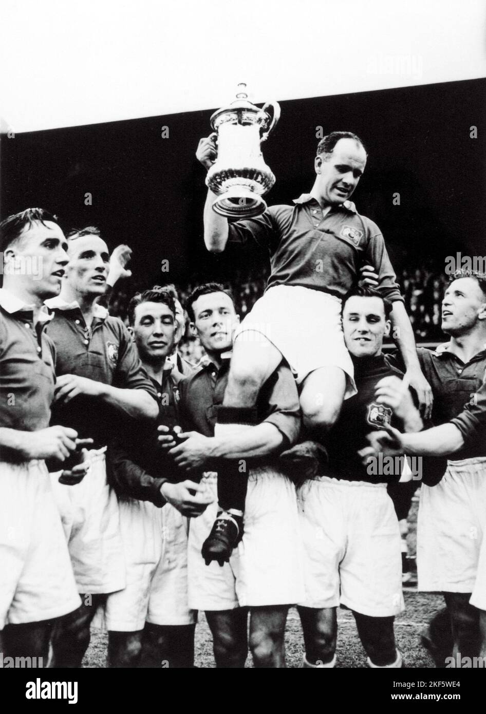 Manchester United captain Johnny Carey (top) shows off the FA Cup as ...