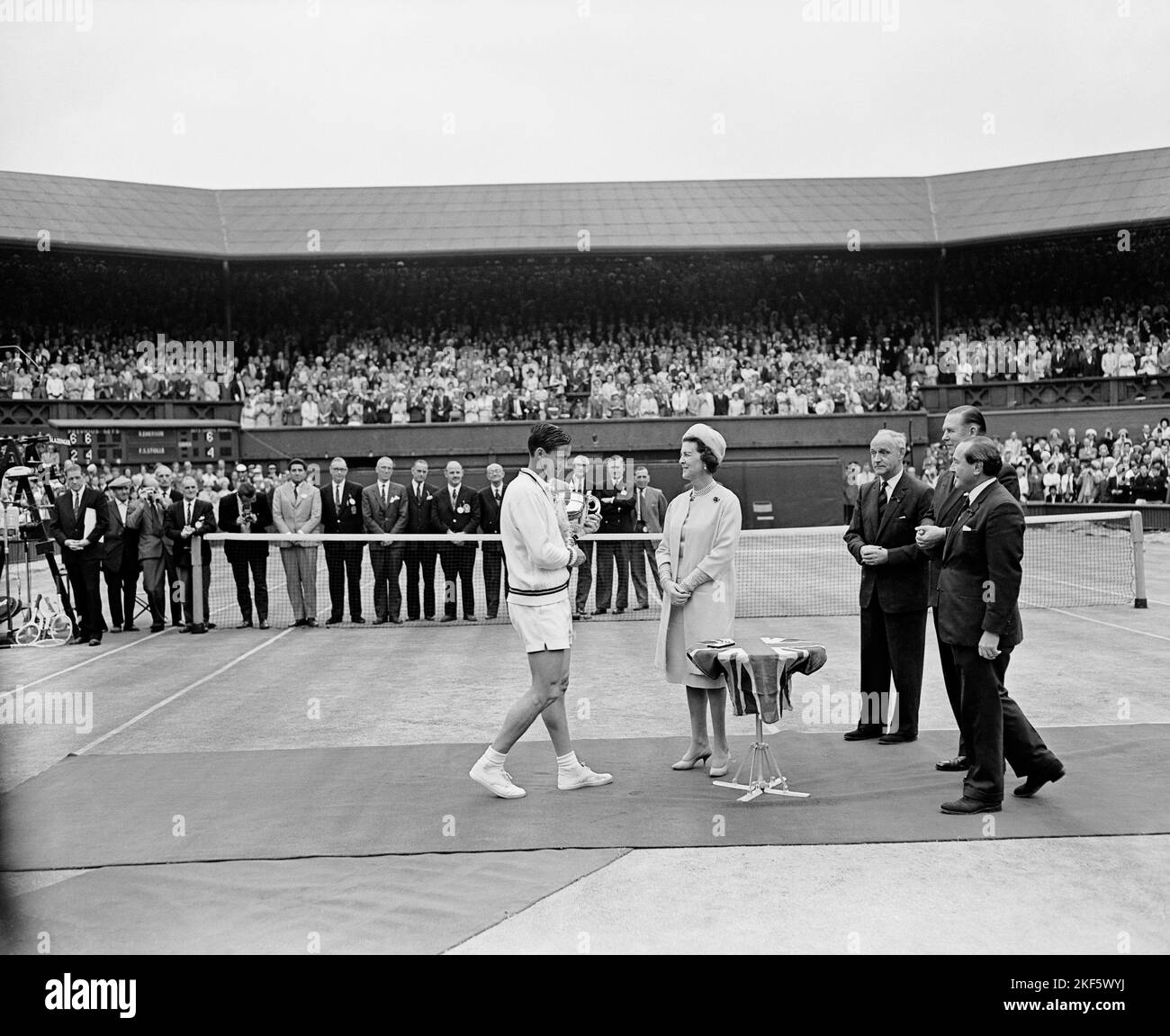 Roy Emerson retreats down the red carpet after receiving the trophy ...