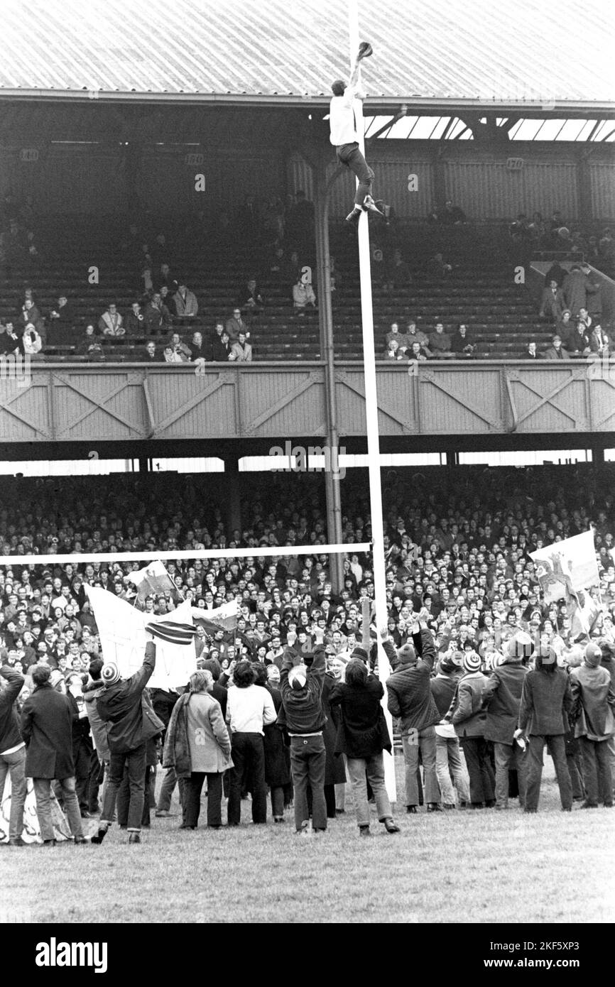 Wales fans who invaded the pitch cheer as one of their number scales ...