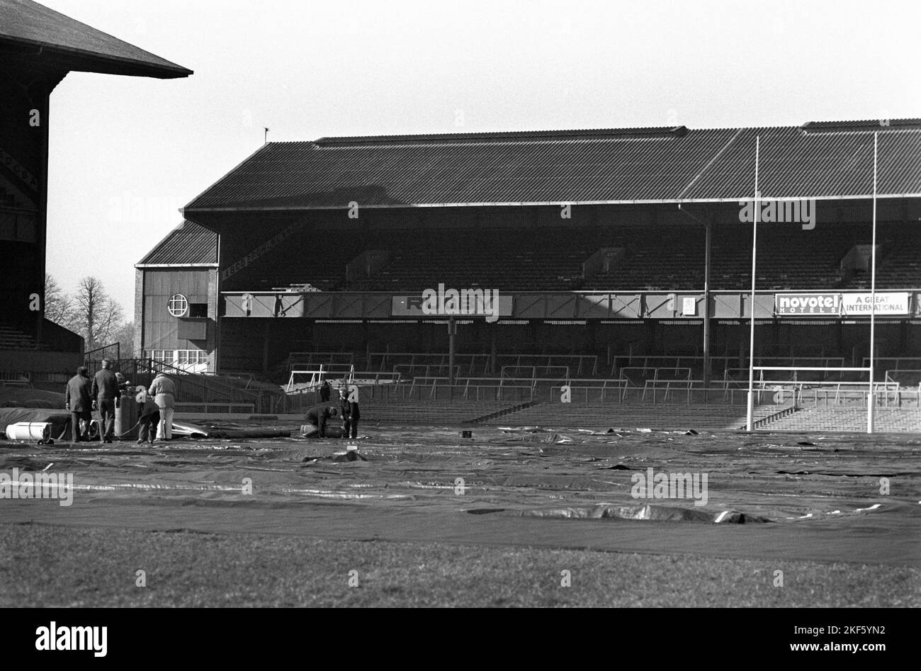 Workmen use hot air fans under the pitch coverings to try to thaw out ...