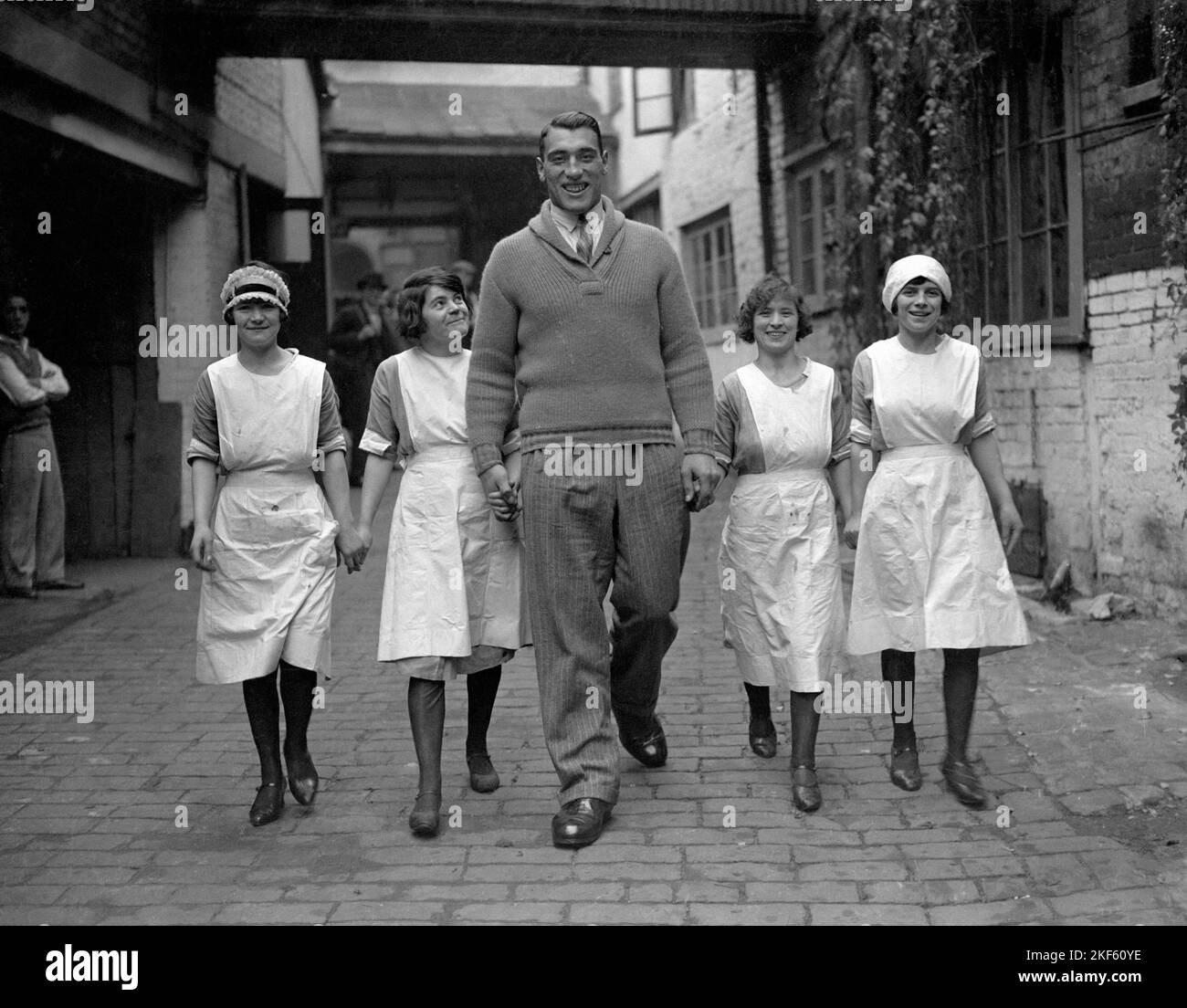 Italian heavyweight boxer Primo Carnara walking with maids Stock Photo ...