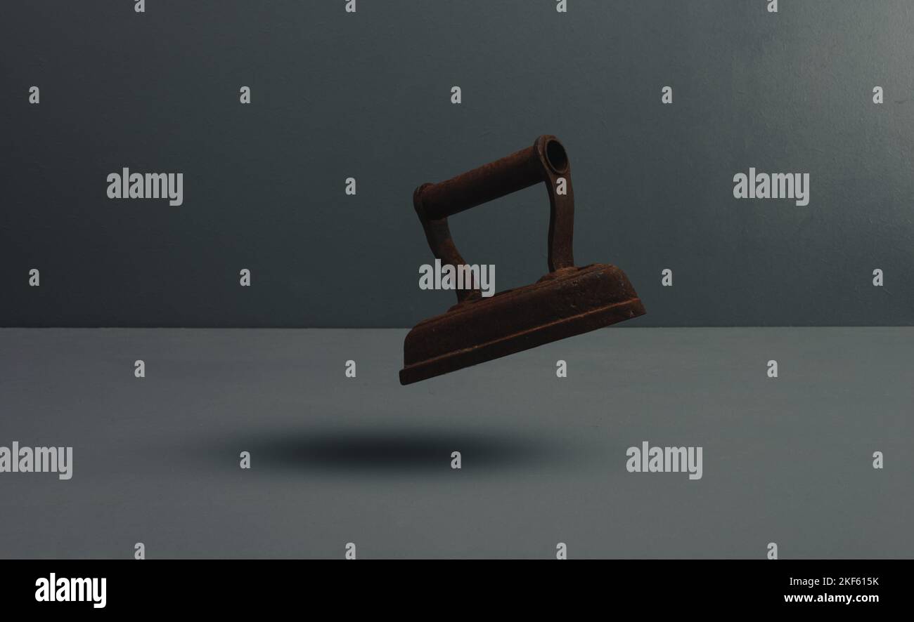 old rusty iron or flat iron floating on grey blue background Stock ...
