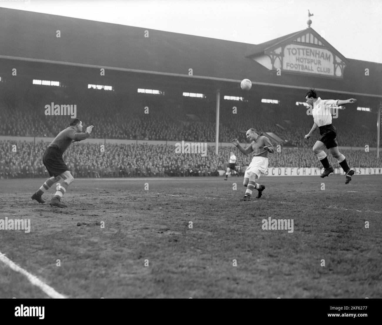 Len Dunquemin, Spurs centre forward, jumps high to head the ball ...