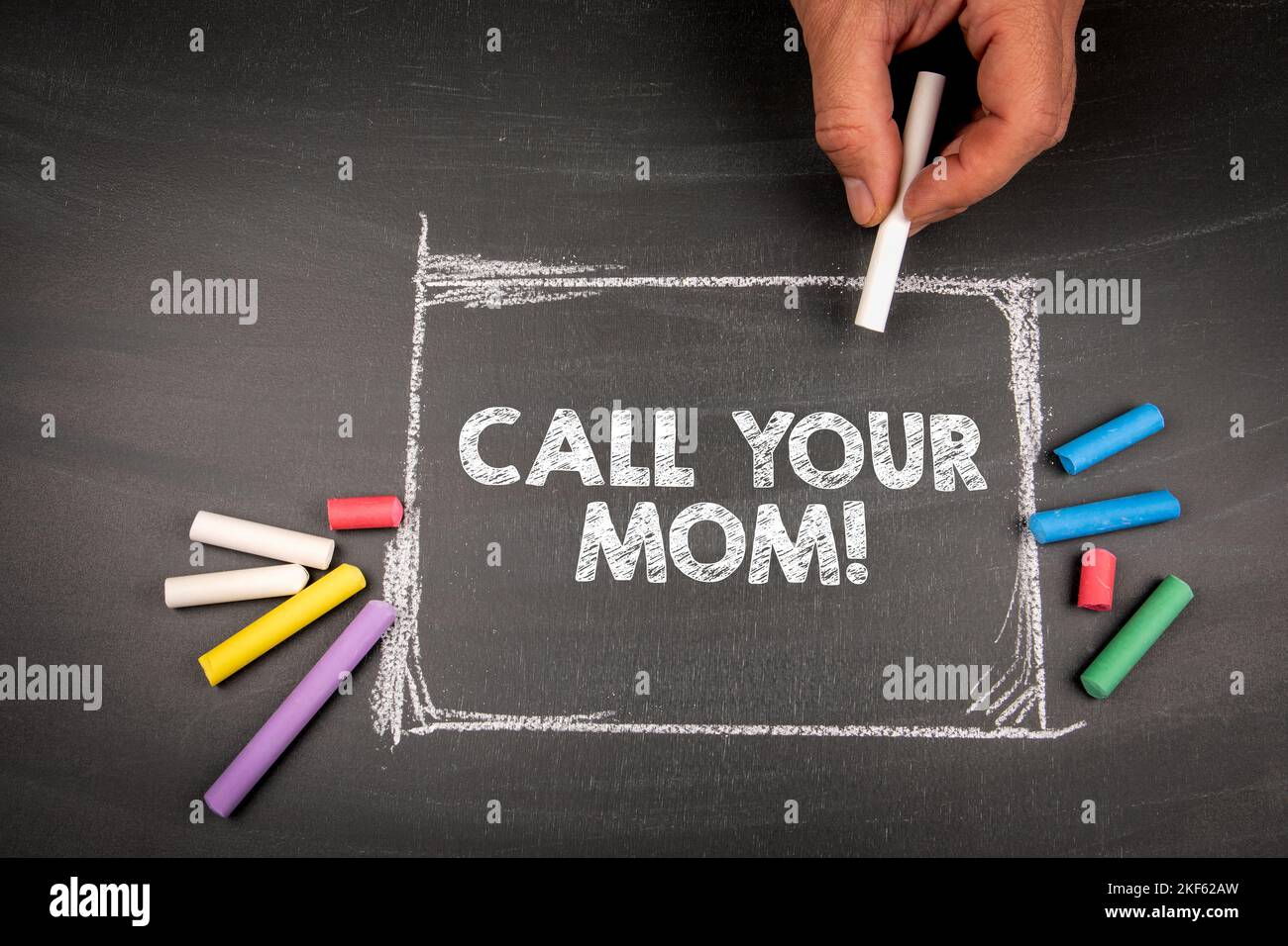 Call Your Mom. Text and colored pieces of chalk on a dark blackboard ...