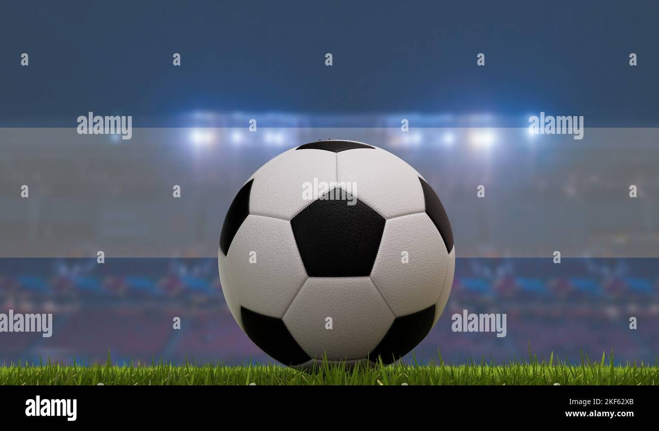 Soccer football ball on a grass pitch in front of stadium lights and ...