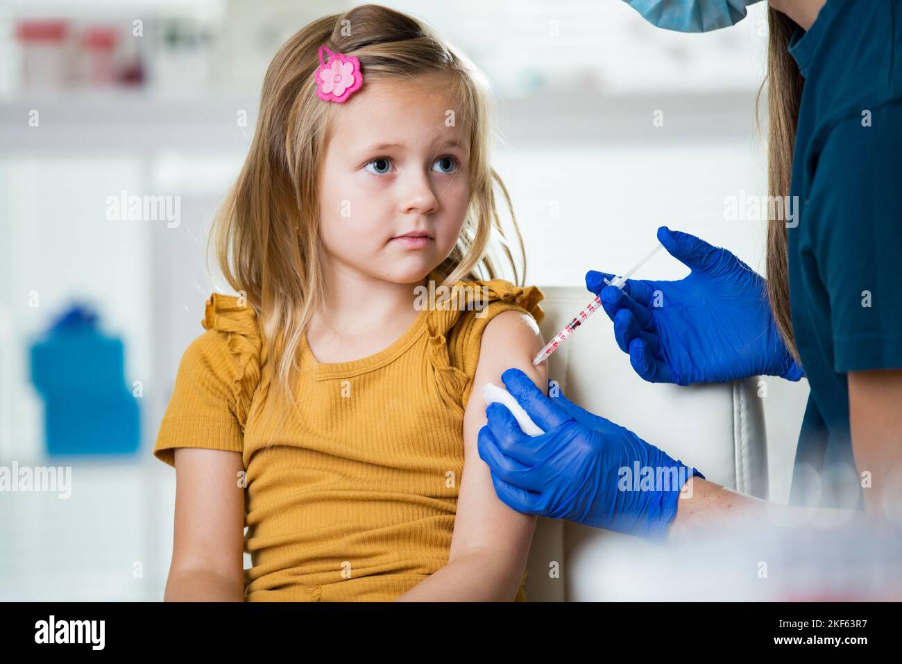Female nurse with surgical mask and in gloves giving vaccine injection ...