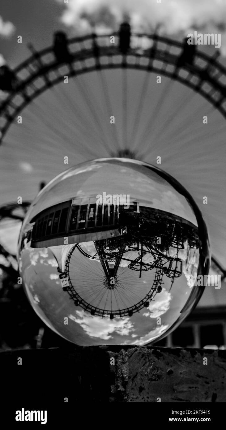 A greyscale shot of a Ferris wheel reflected on a small iceball Stock ...