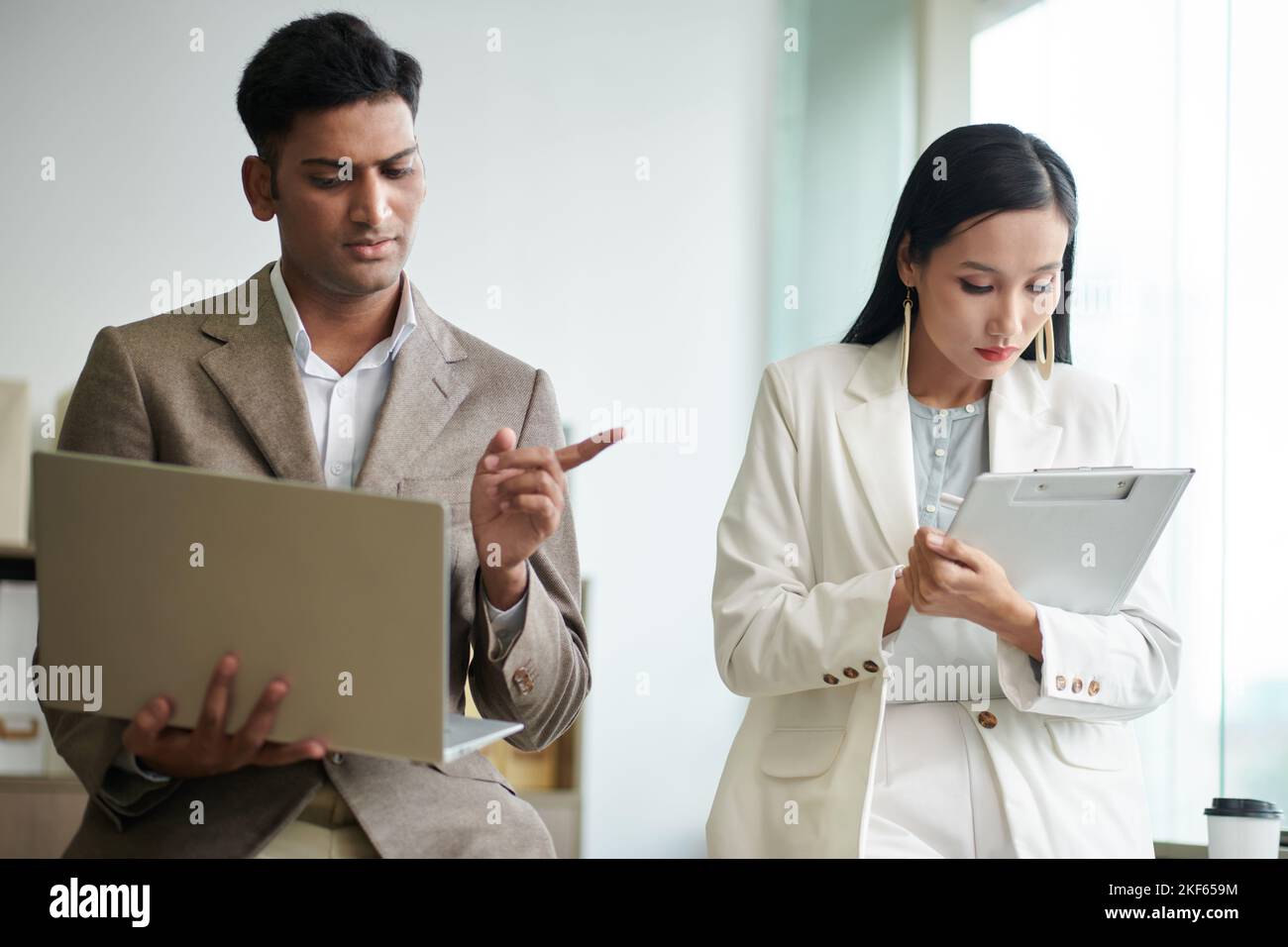 Serious businessman asking colleague about details in product ...