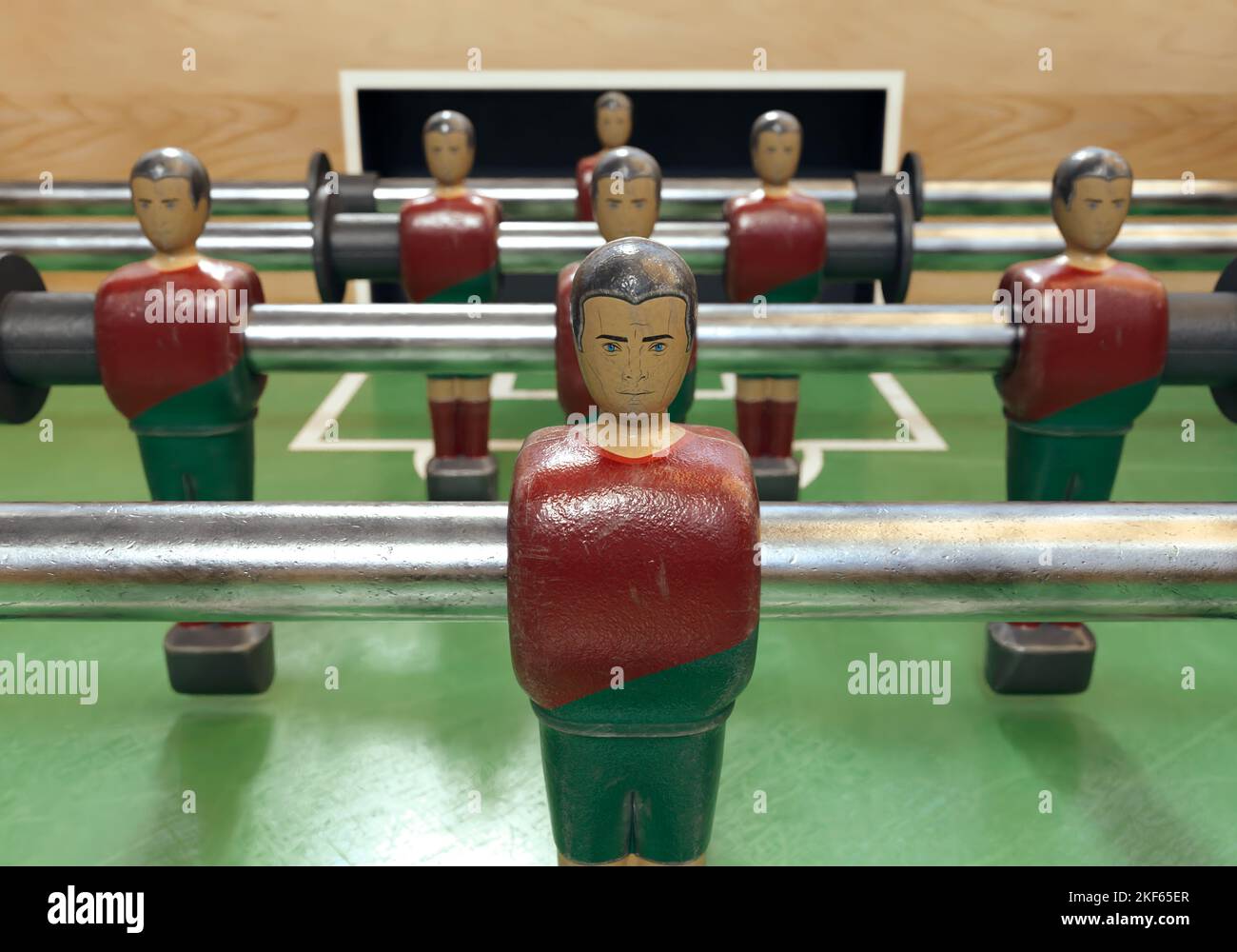 One side of a vintage foosball or table football table with worn metal ...