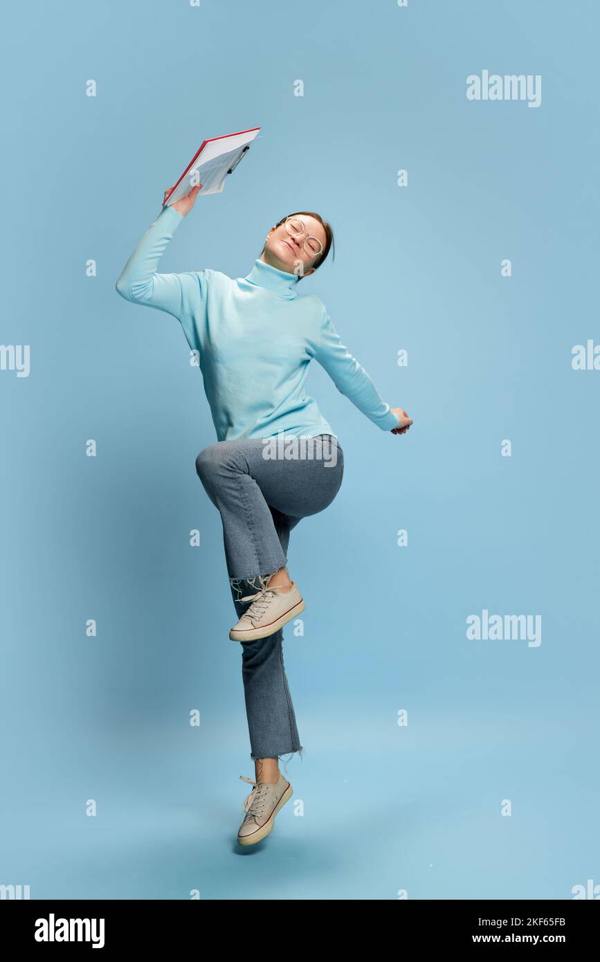 Portrait of young woman cheerfully posing with documents isolated over ...