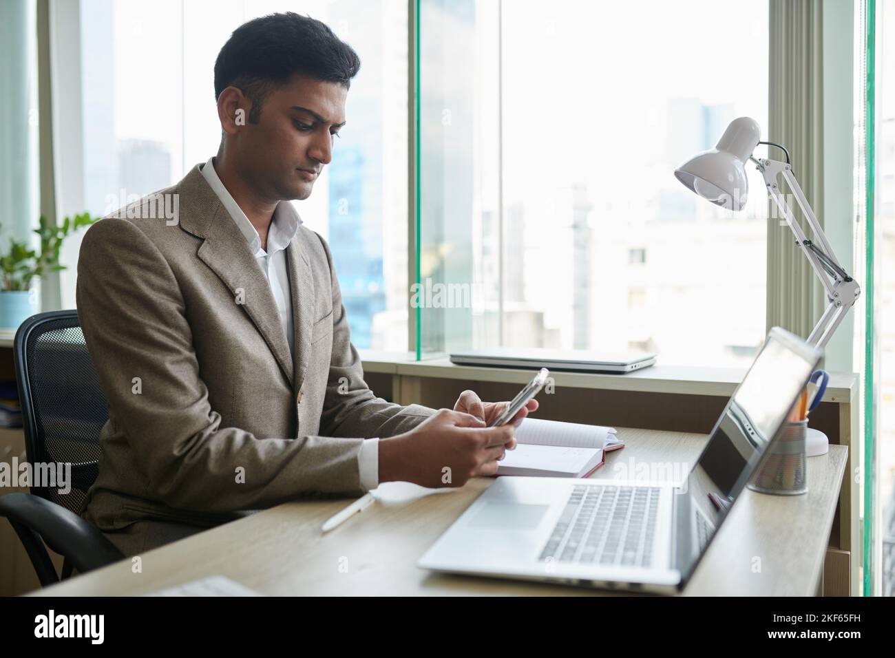Serious businessman answering text messages from colleagues when ...