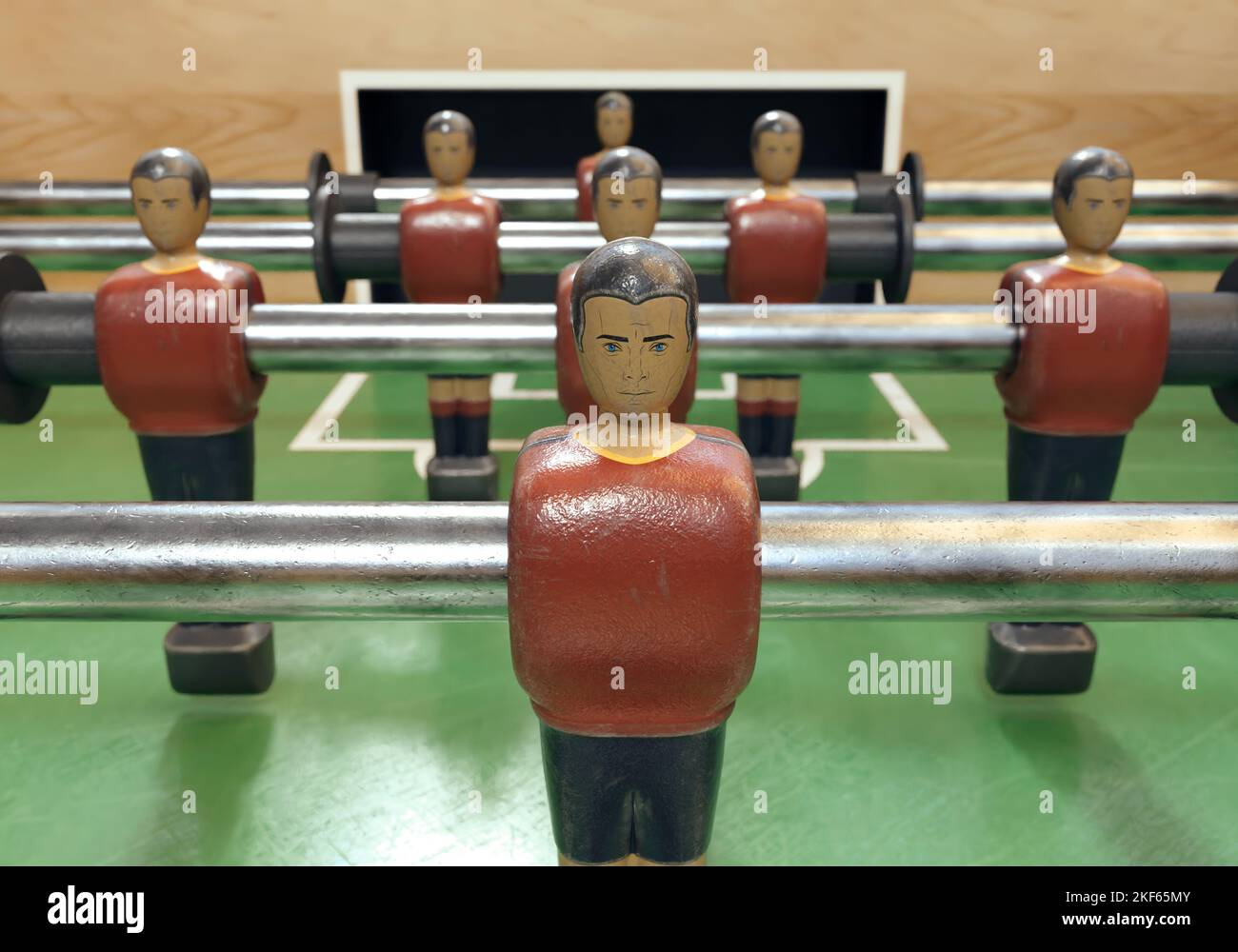 One side of a vintage foosball or table football table with worn metal ...