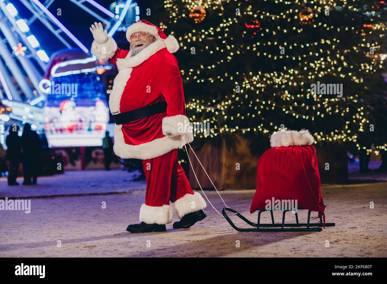 Full length photo of funky fat aged santa pull gifts sack sledge walk ...