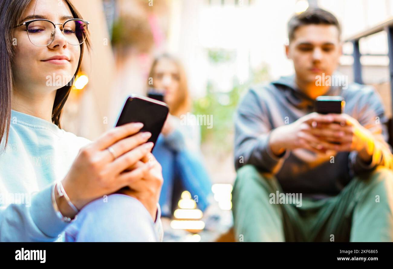 Group of friends using cellphones - Students sitting in a stairs and ...