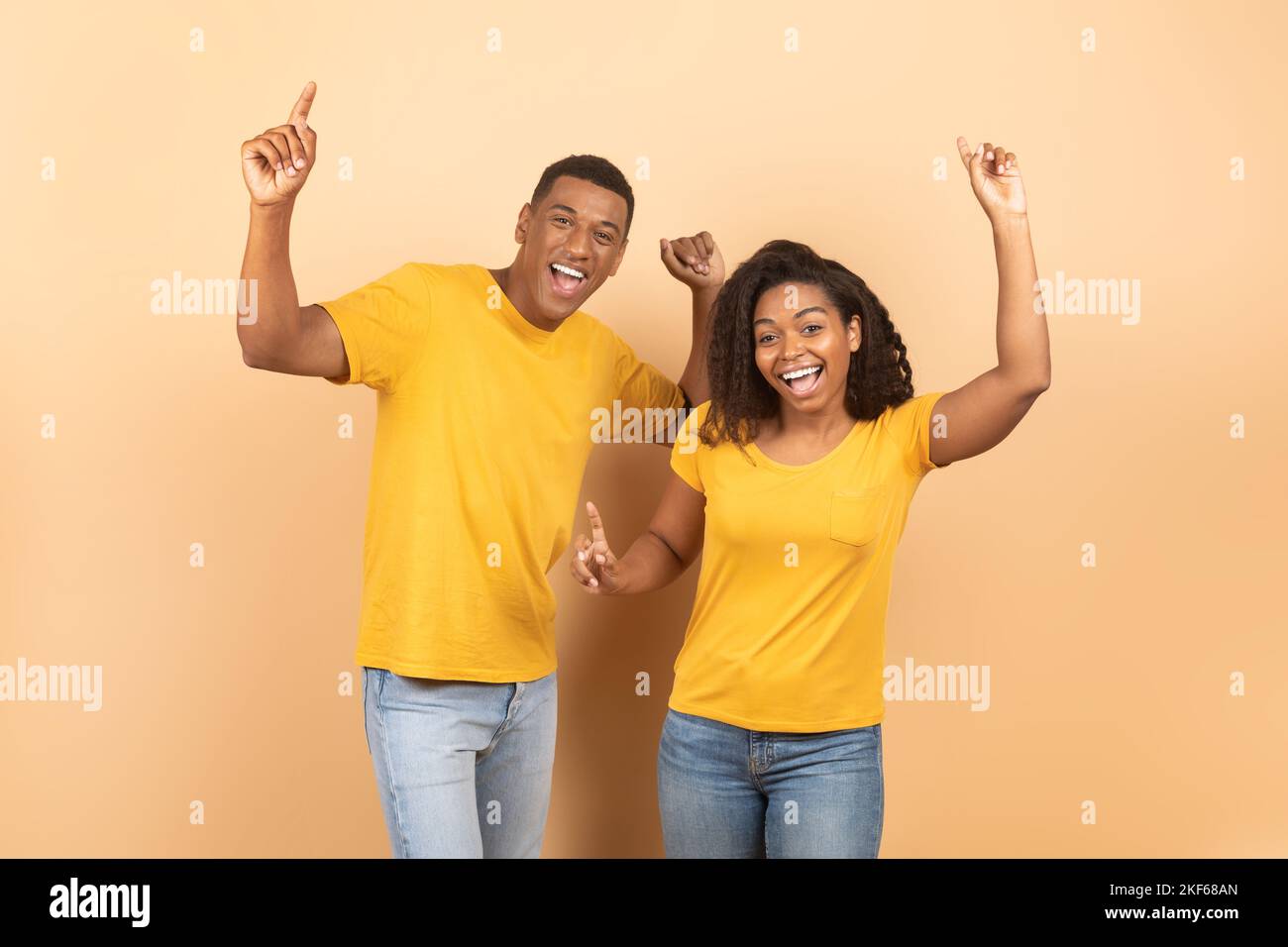 Excited young black couple dancing and enjoying favourite music ...
