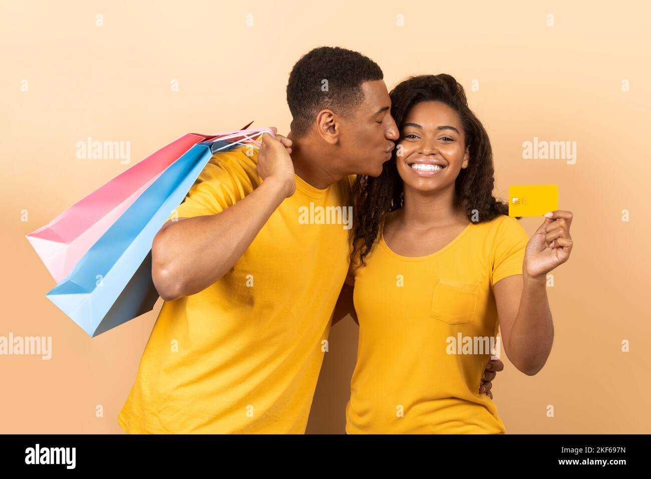 Happy black couple after shopping, woman showing credit card while man ...