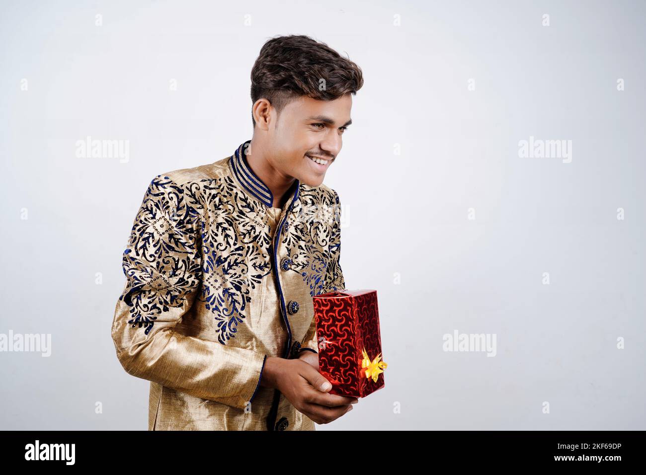 Indian man in ethnic wear and Holding gift box in hand , isolated over ...