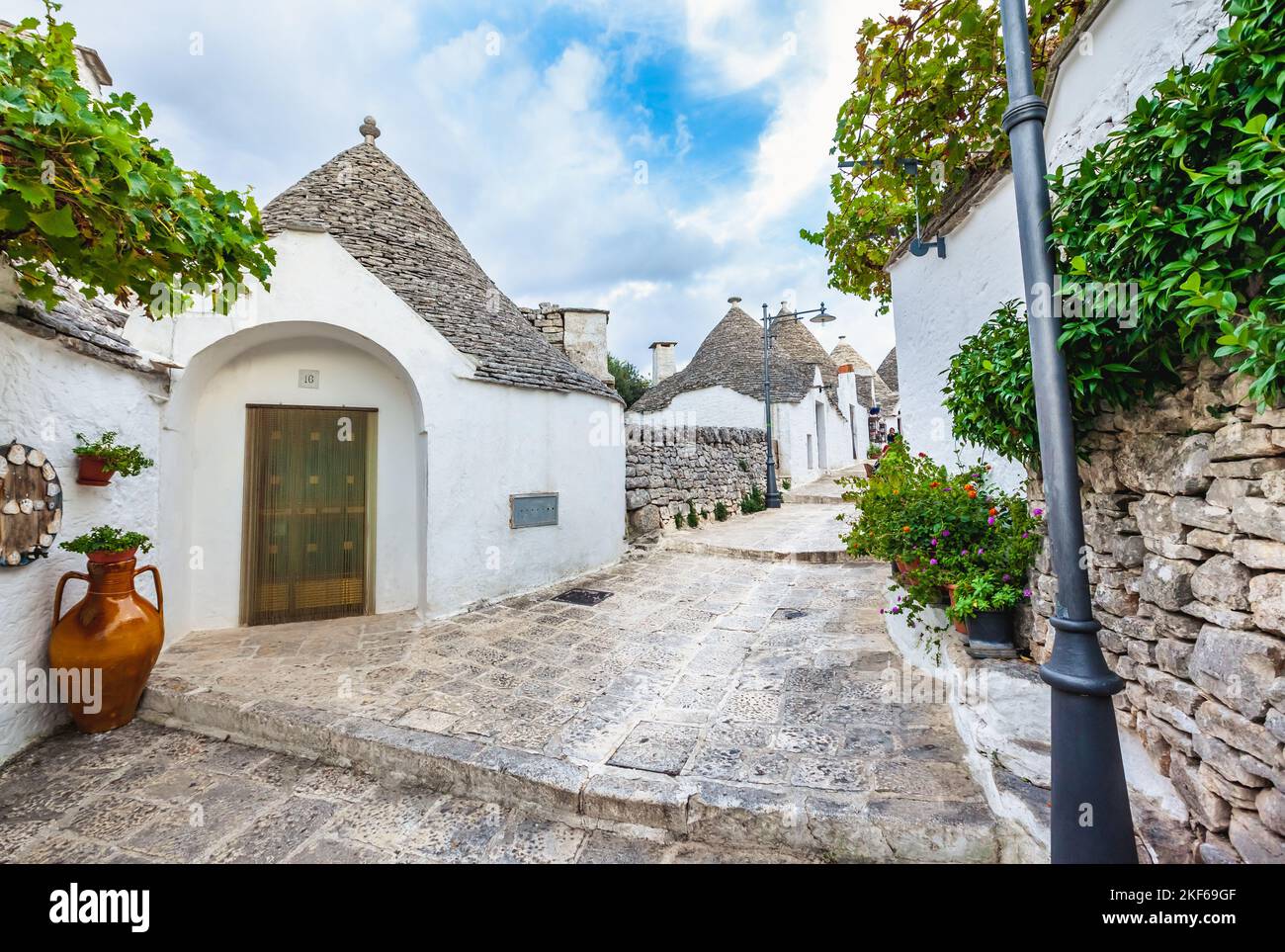 Beautiful town of Alberobello with Trulli houses among green plants and ...