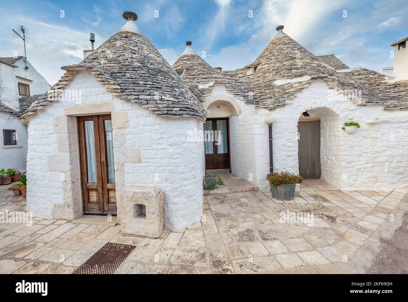 Beautiful town of Alberobello with Trulli houses among green plants and ...