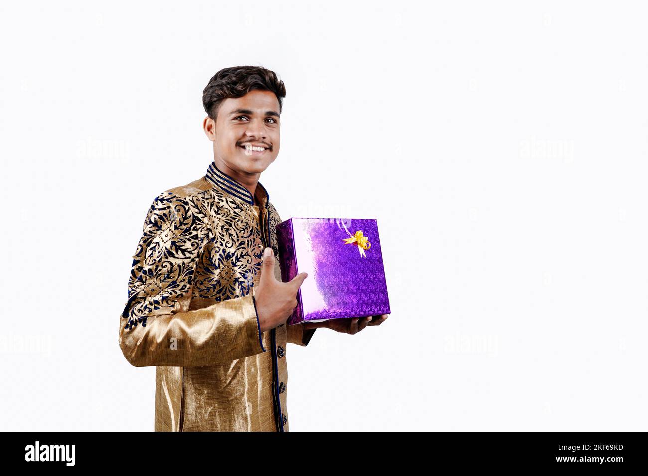 Indian man in ethnic wear and Holding gift box in hand , isolated over ...