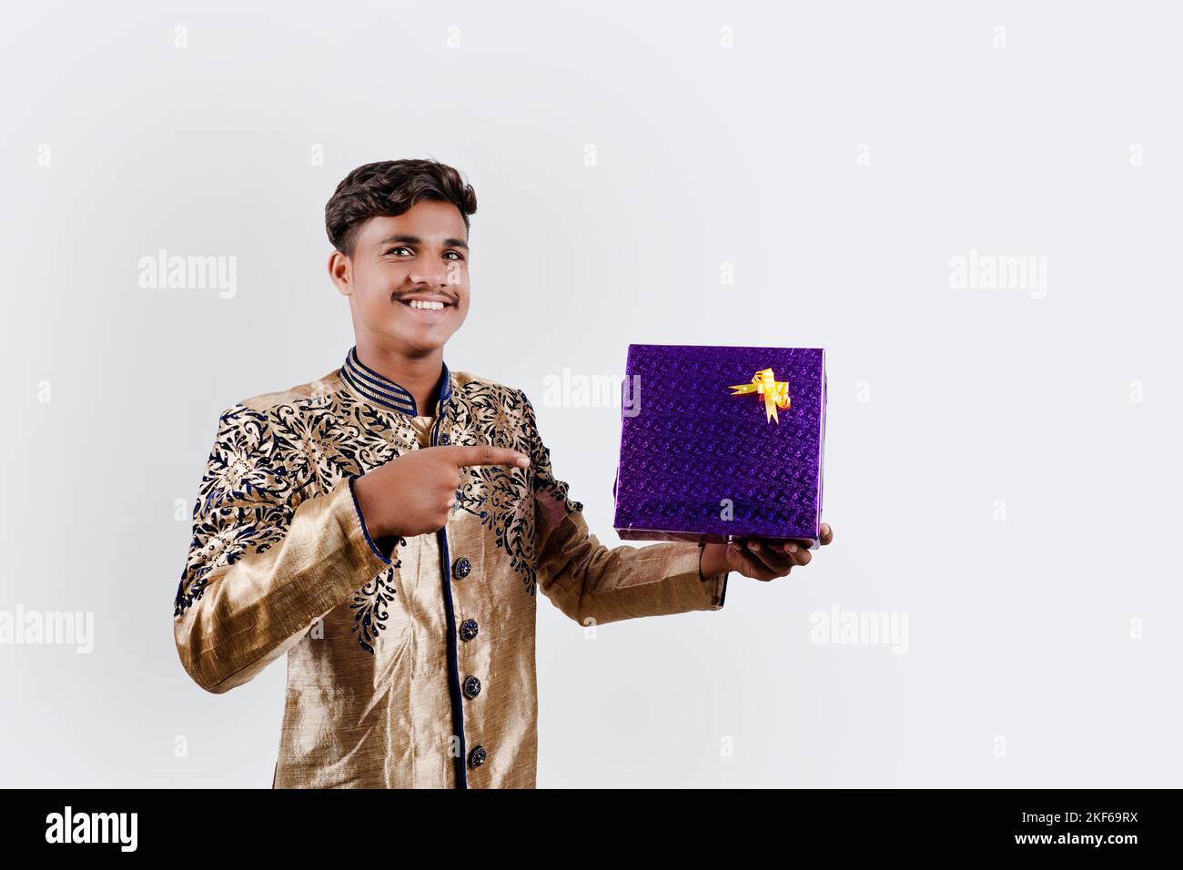 Indian man in ethnic wear and Holding gift box in hand , isolated over ...